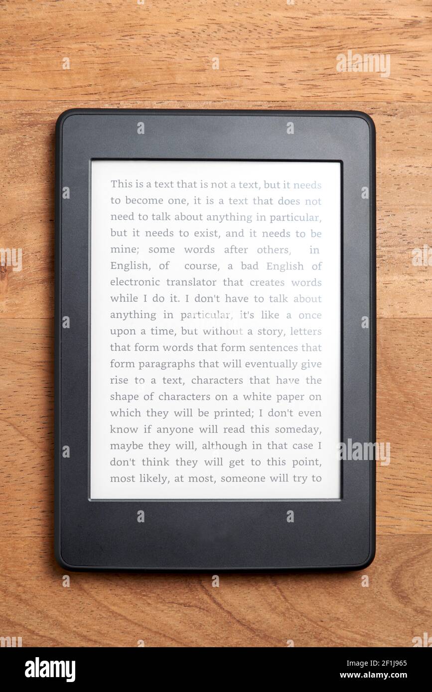 Electronic reader with text on the screen on a wooden surface. Concepts ...