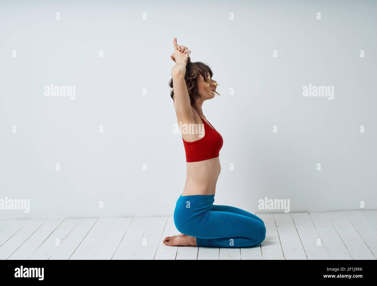A Slender Woman Shows Exercises For Yoga In A Bright Room Sitting On