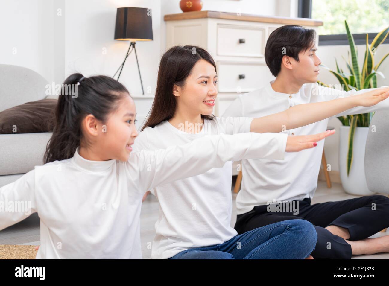 Young Asian family doing exercise together at home Stock Photo - Alamy