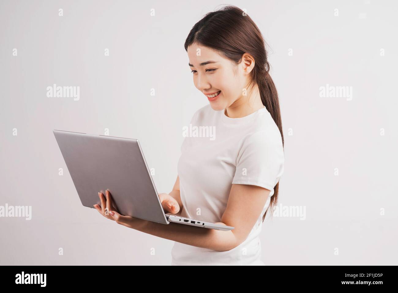 Portrait of young girl holding computer on white background Stock Photo ...