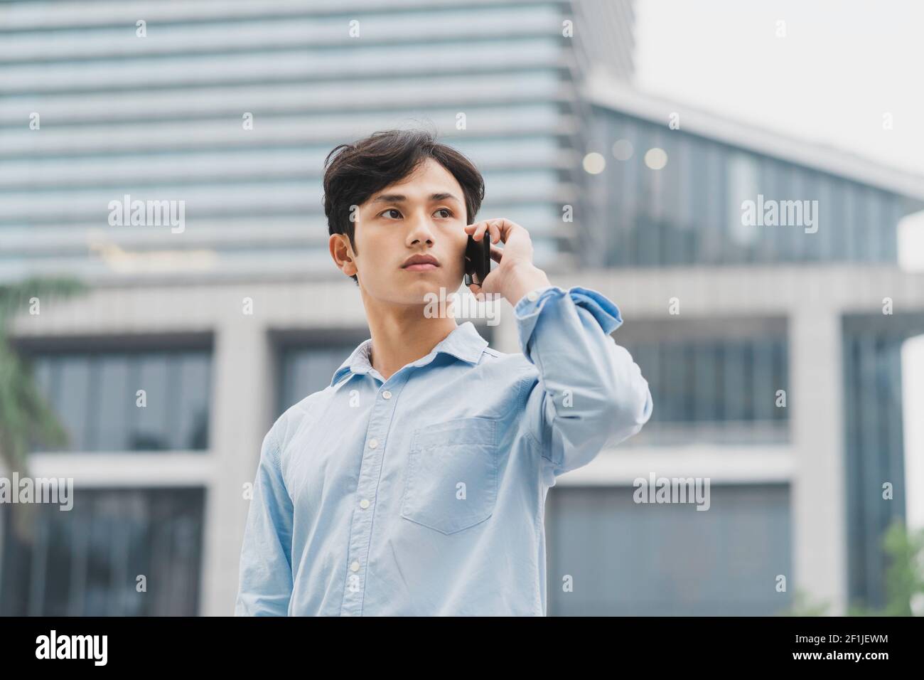 Asian businessman is calling outside Stock Photo - Alamy
