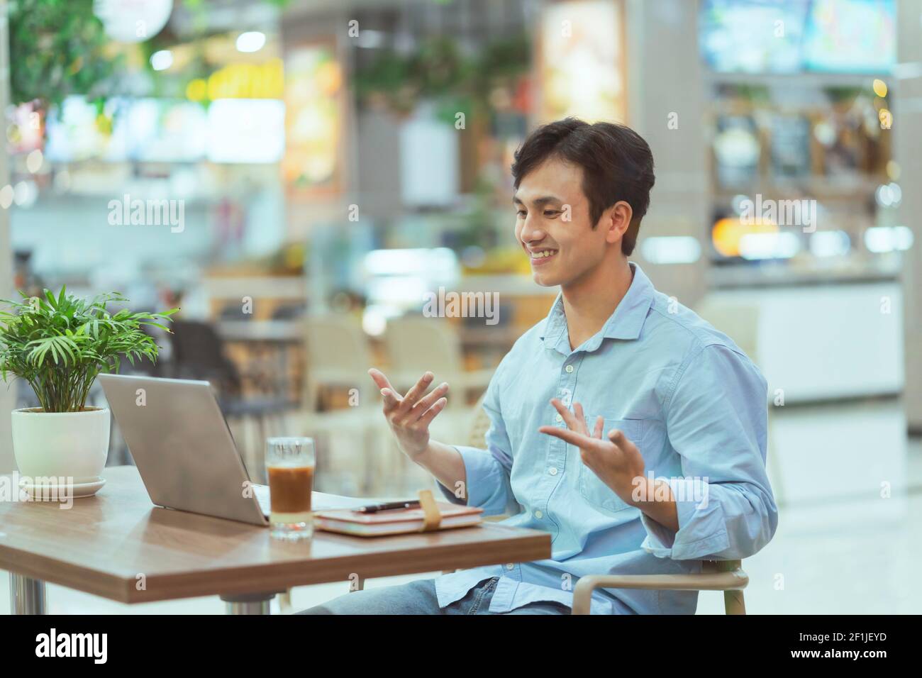 Asian man sitting working alone at a coffee shop Stock Photo - Alamy