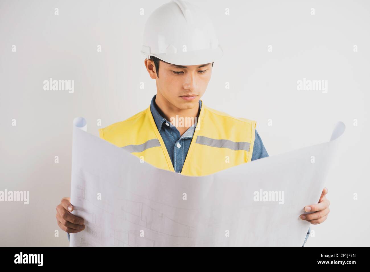 Asian construction engineer reading the technical drawing Stock Photo ...