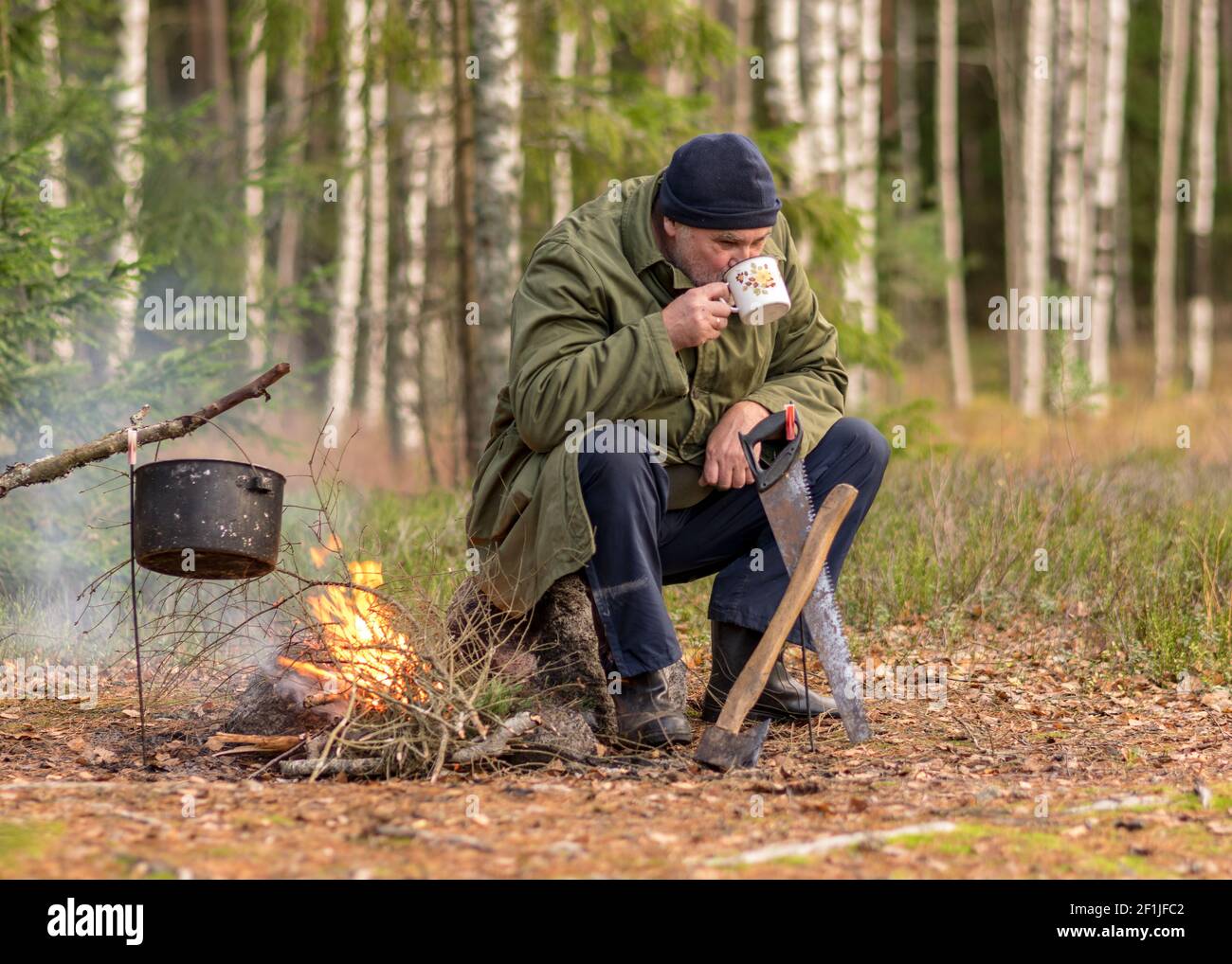 a forester in the forest drinks tea at rest, blurred forest background ...