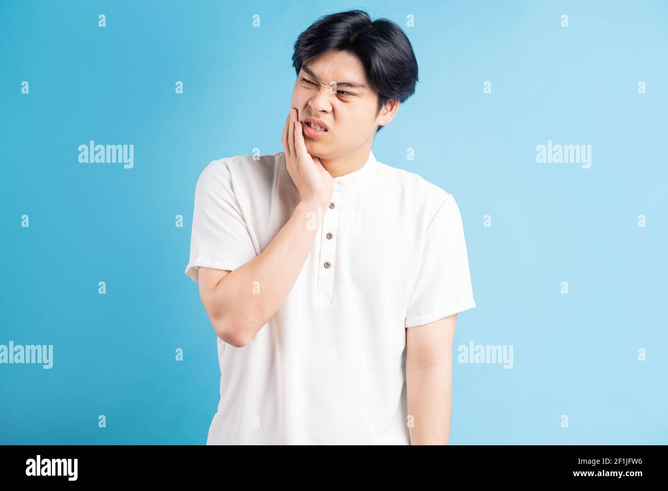 Asian man is upset about a toothache Stock Photo - Alamy