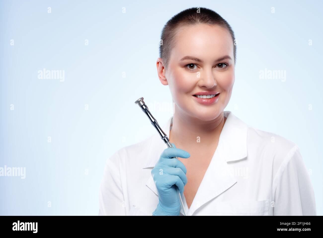 Portrait of a woman dermatologist holding cosmetic device attachment ...