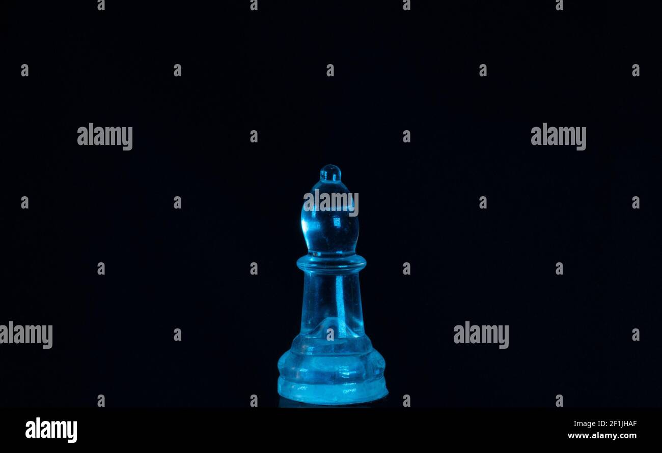 opaque crystal bishop chess piece using filtered blue light isolated on ...