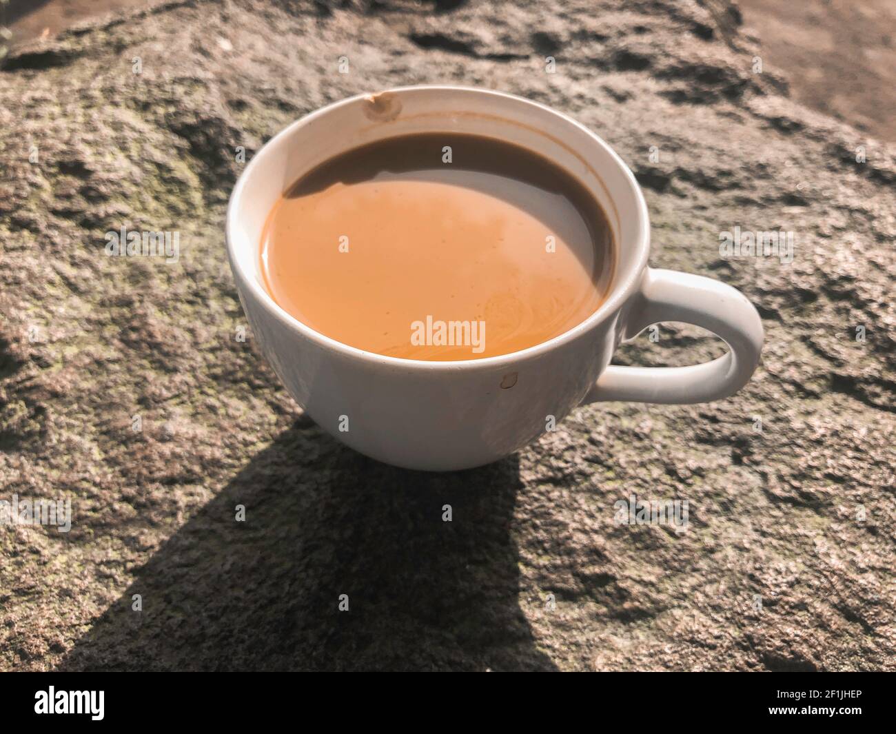 White cup of creamy coffee isolated on stone background Stock Photo - Alamy