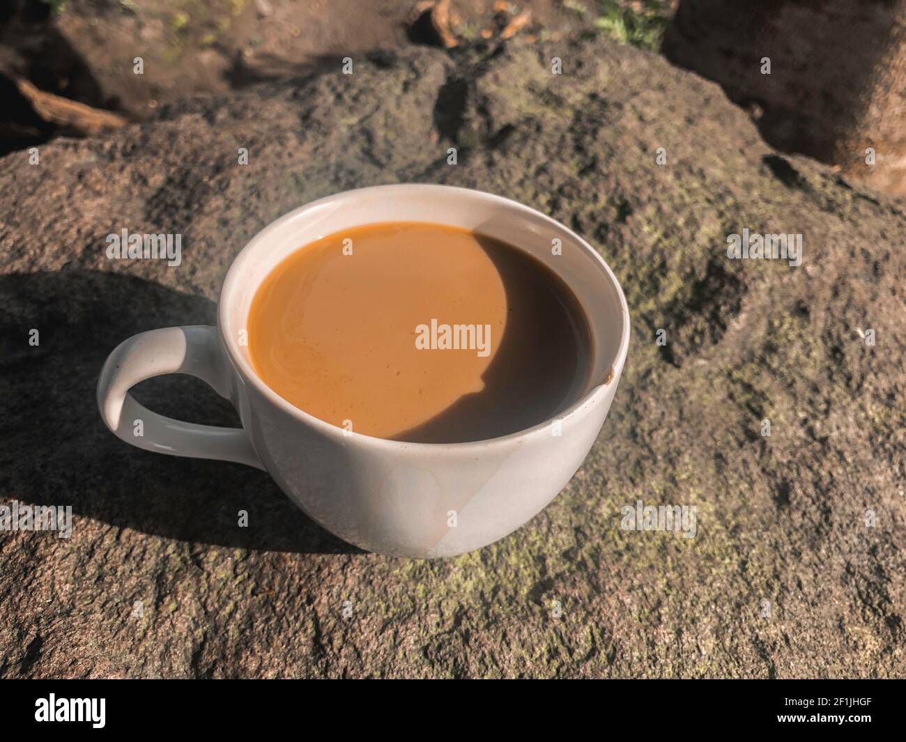 White cup of creamy coffee isolated on stone background Stock Photo - Alamy