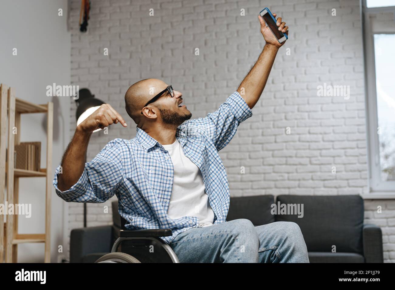 Disabled man sitting in a wheelchair and using Smartphone Stock Photo ...