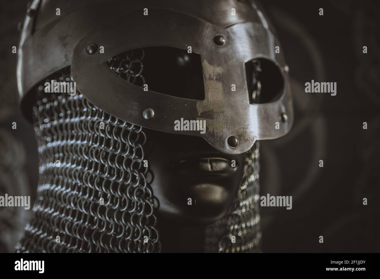 Viking helmet with chain mail of iron on red shield of wood and golden ...