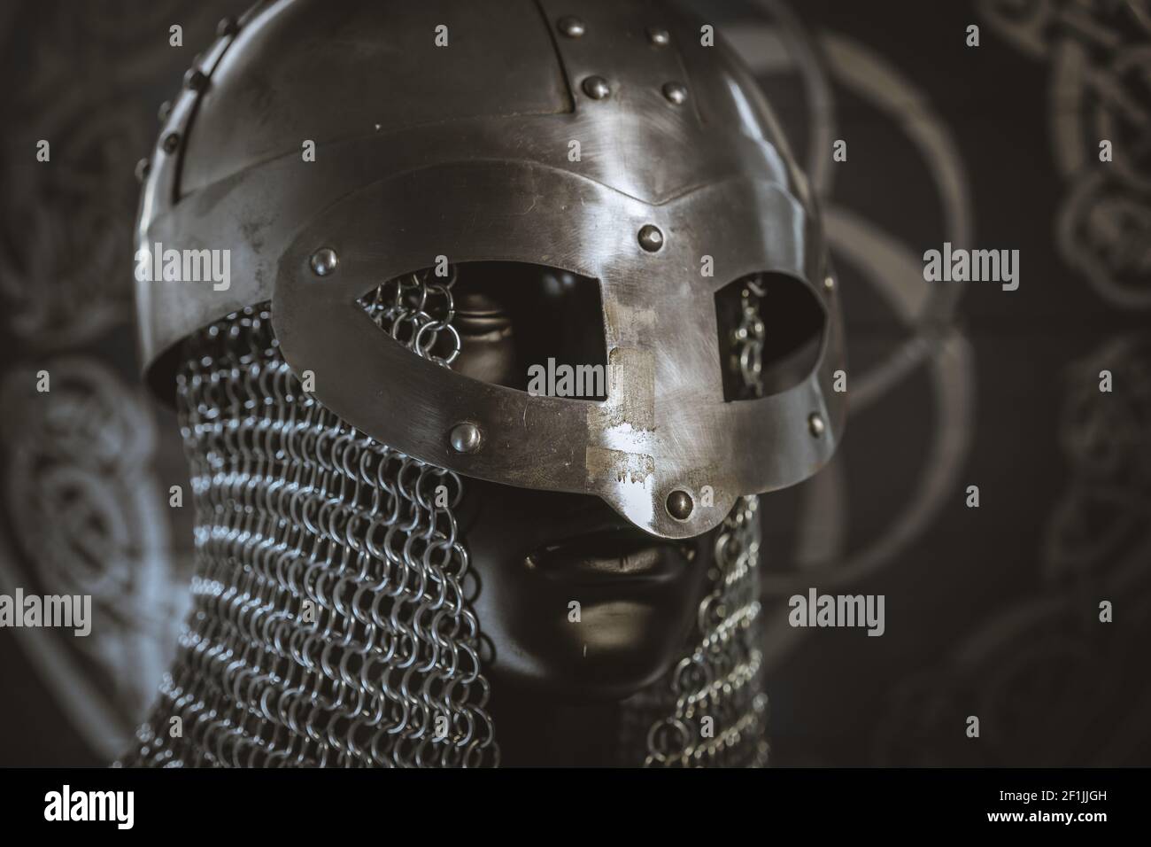 Viking helmet with chain mail of iron on red shield of wood and golden ...