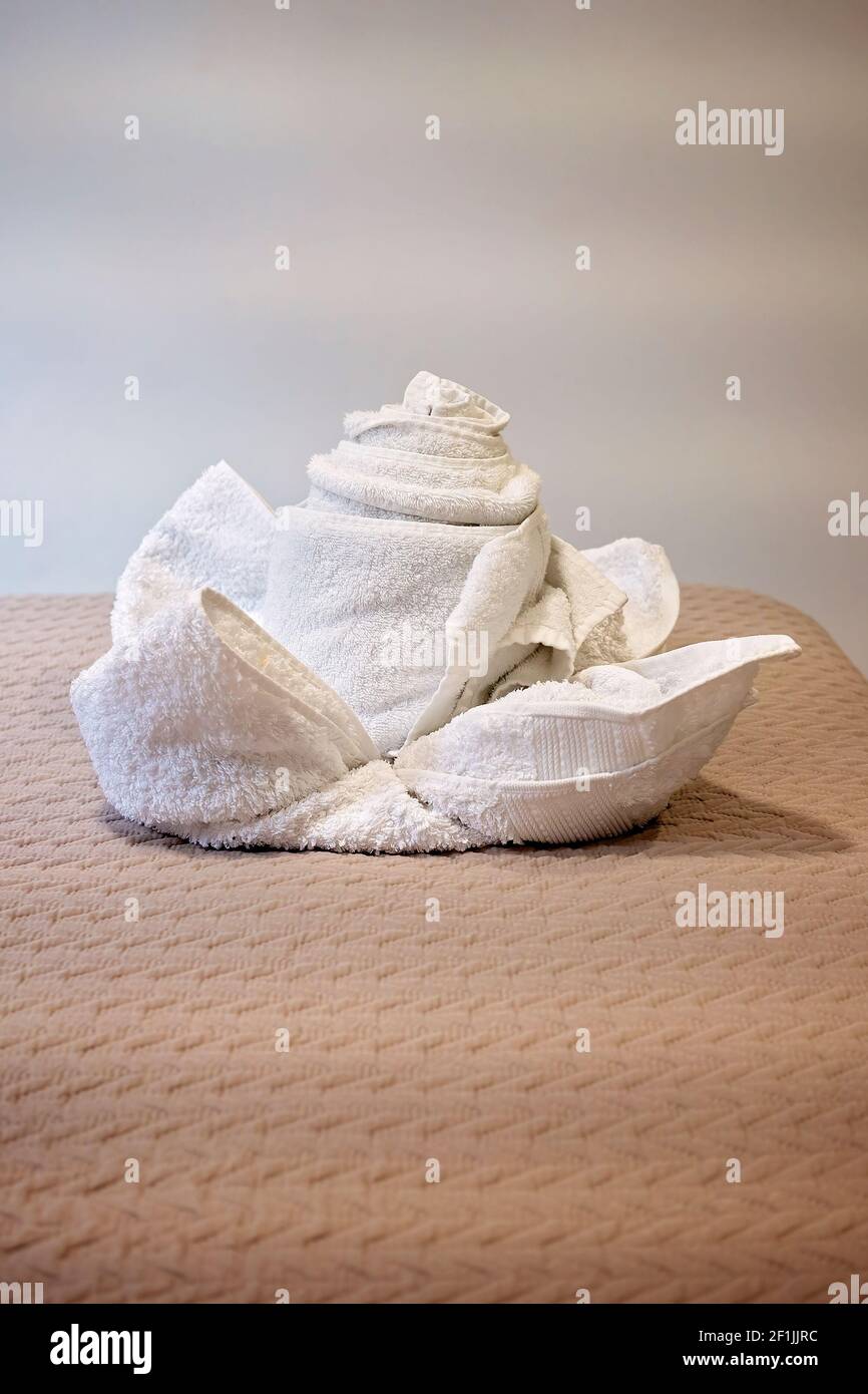 Two bath towels folded into a decorative flower shape - towel art on a ...