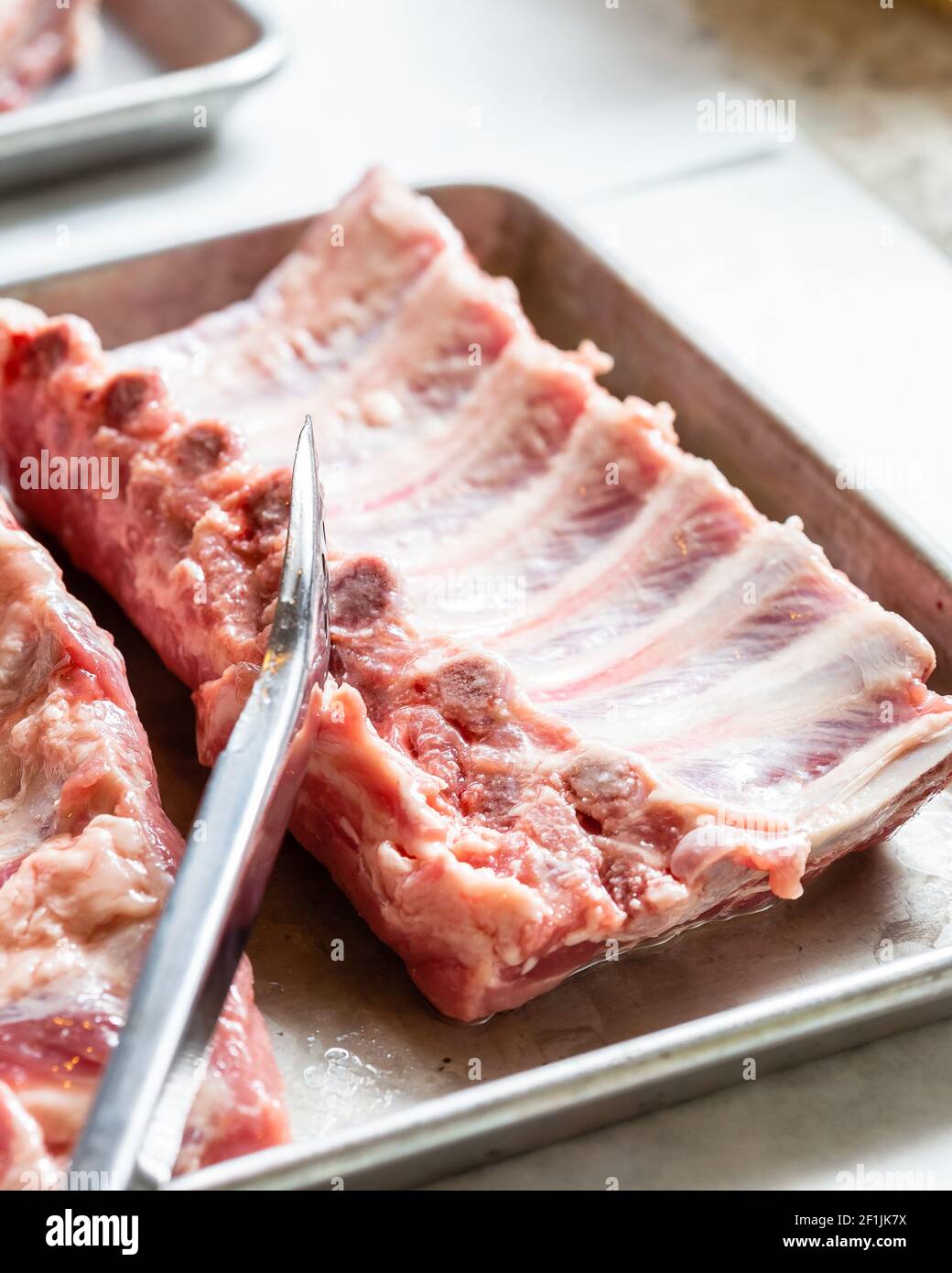 Spare ribs uncooked on stainless steel platter. Preparing bbq ribs ...