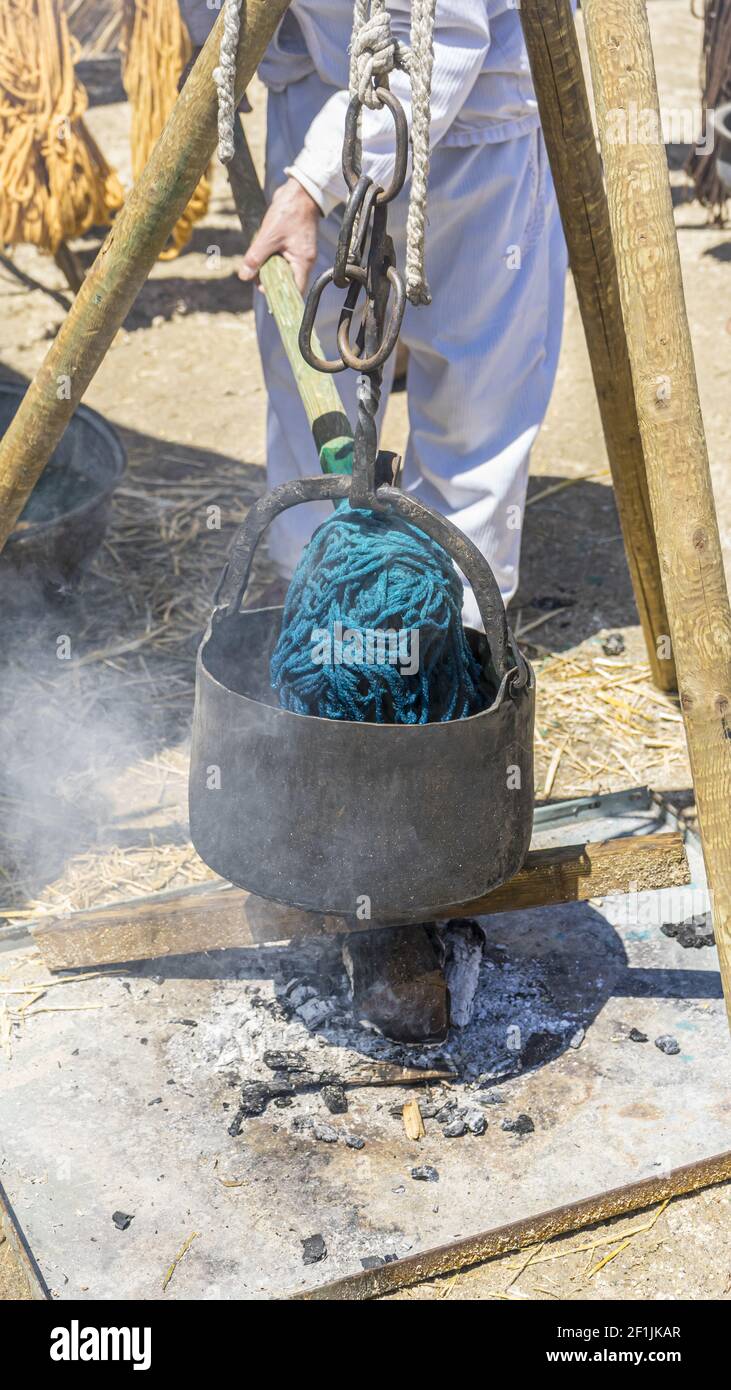 Handmade dyeing of fabrics and wool in a cauldron with colored dyes in ...