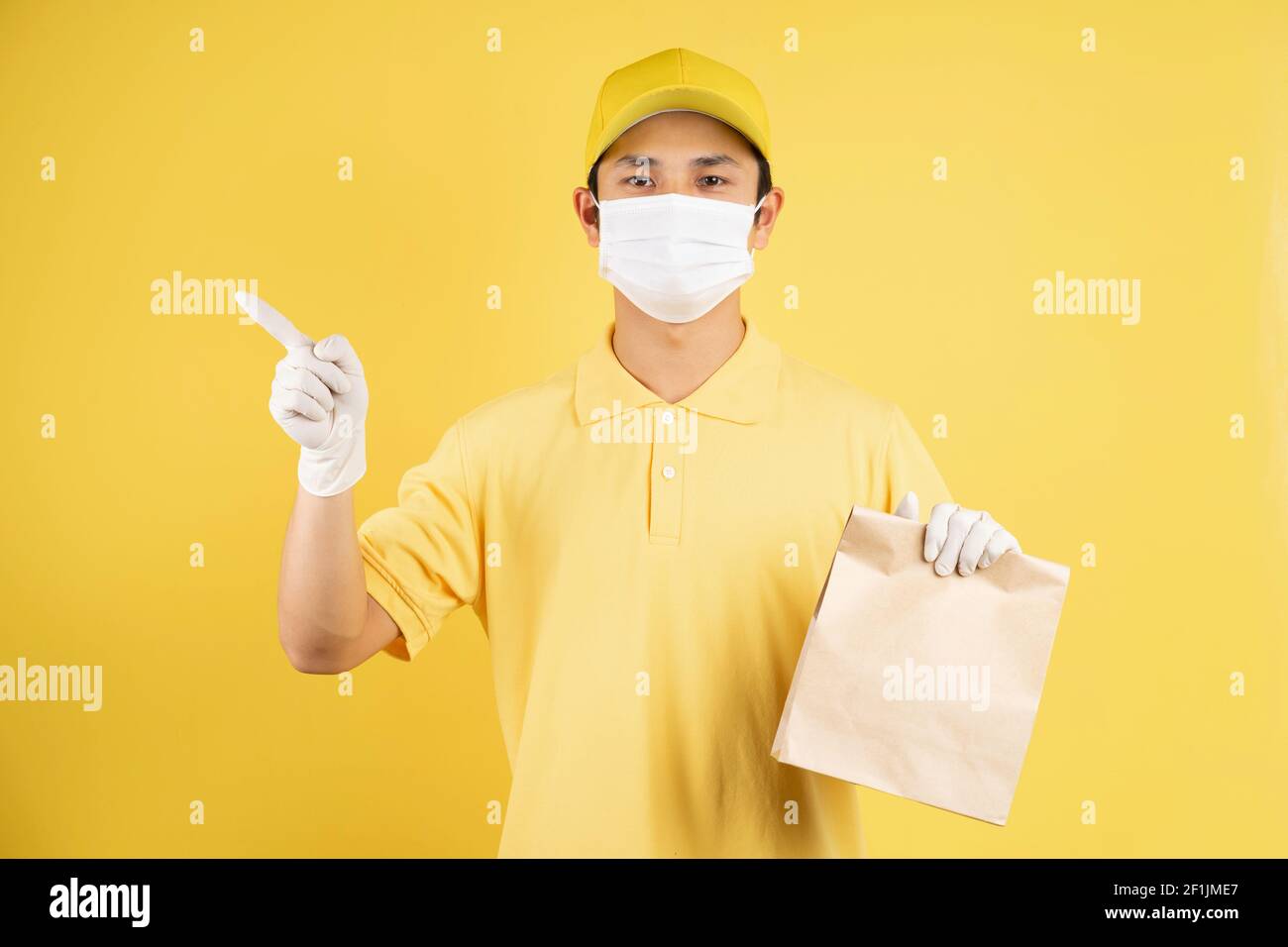 Portrait of delivery male holding shopping bags on background Stock ...