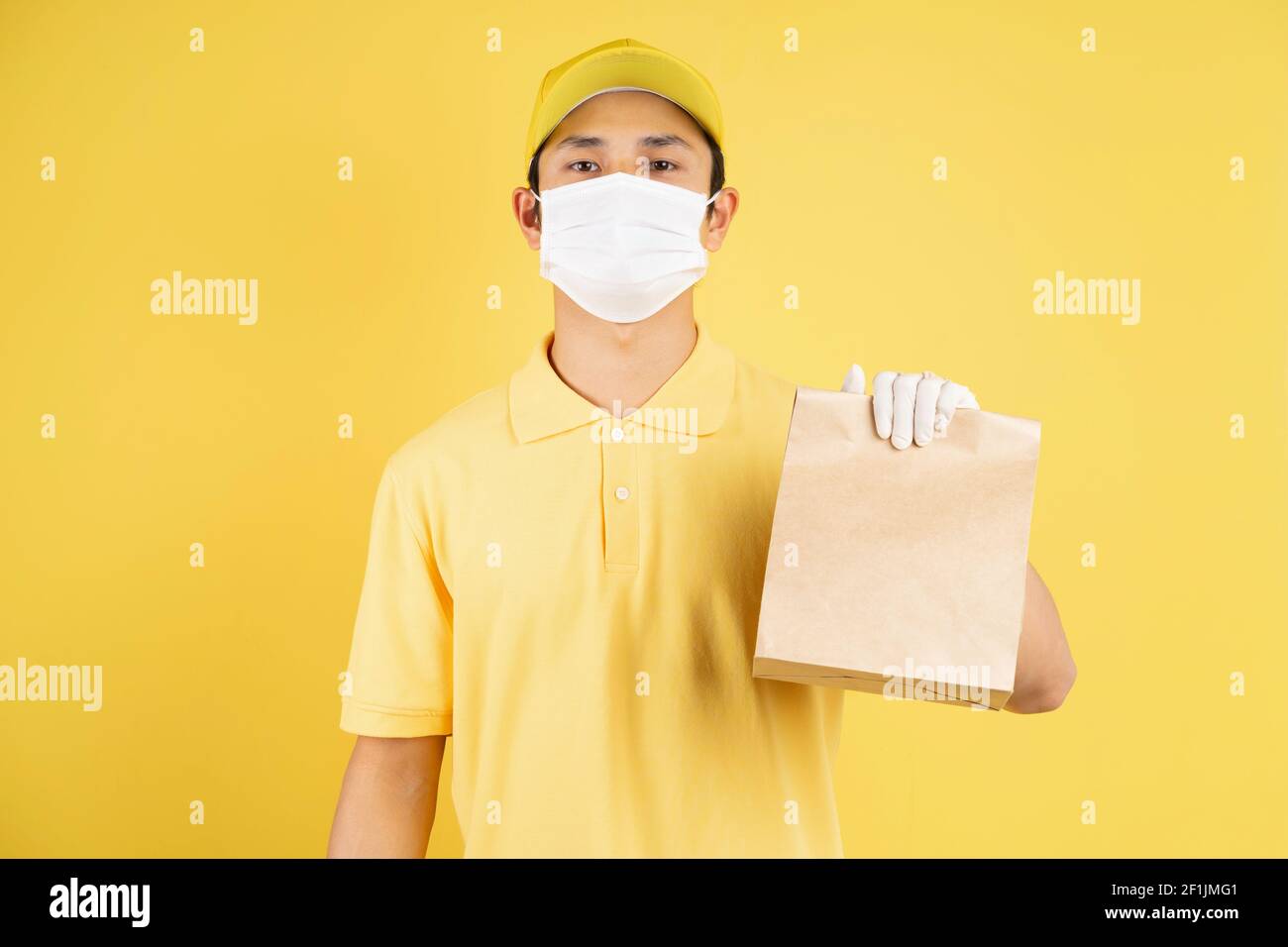 Portrait of delivery male holding shopping bags on background Stock ...