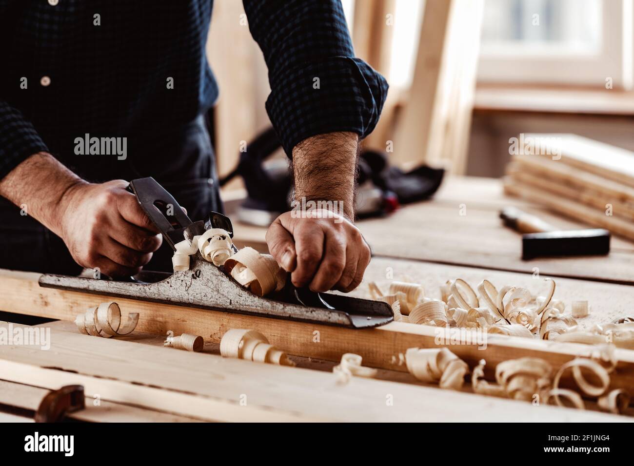 Carpenter's hands planing a plank of wood with a hand plane Stock Photo ...