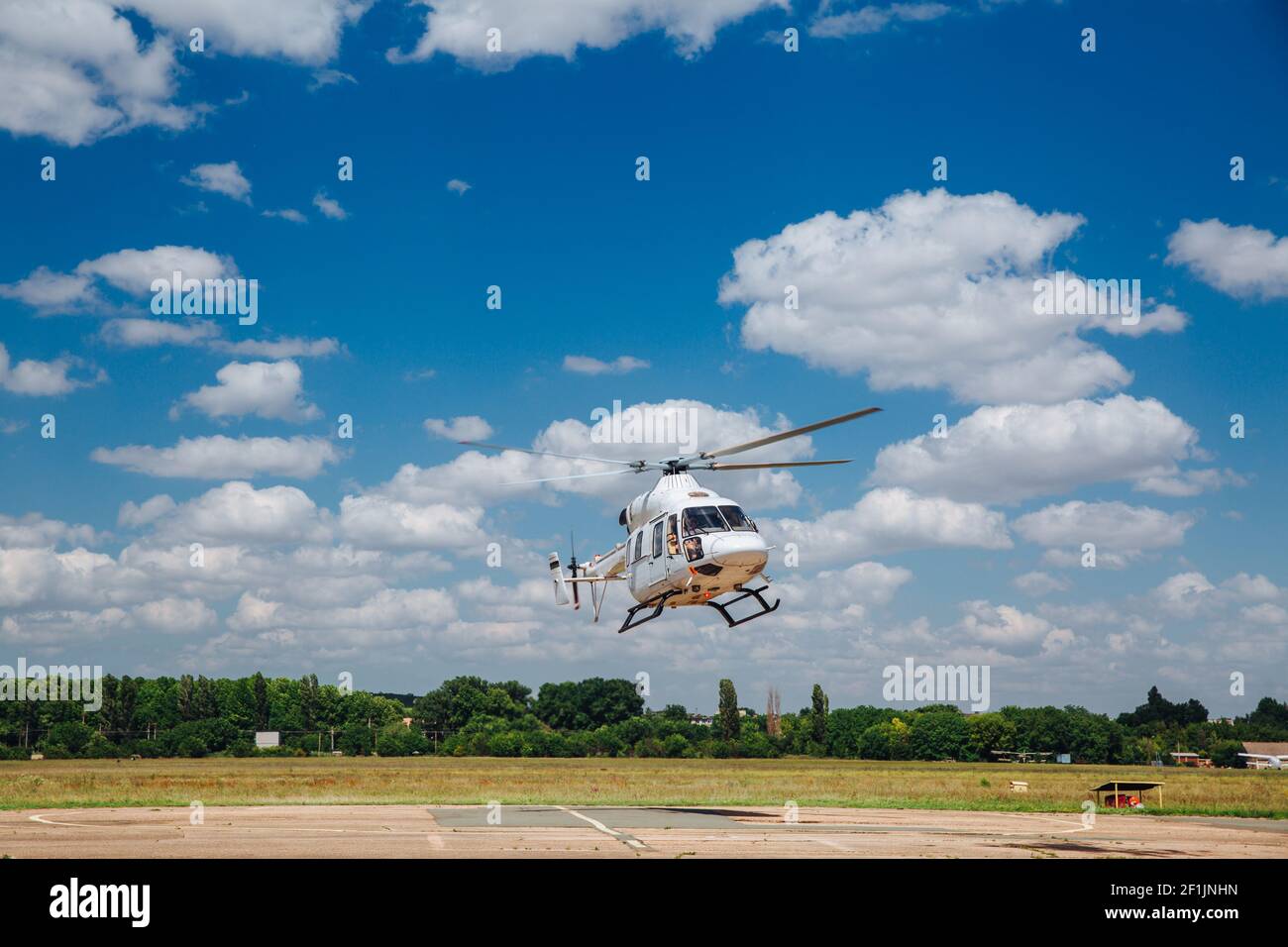 White helicopter takes off from the take-off area Stock Photo - Alamy