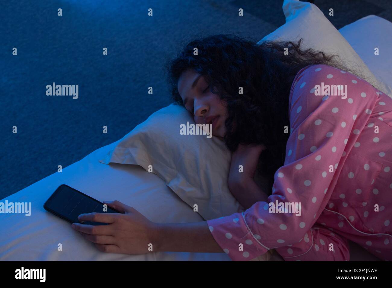 A TEENAGE GIRL SLEEPING WITH PHONE IN HAND Stock Photo - Alamy