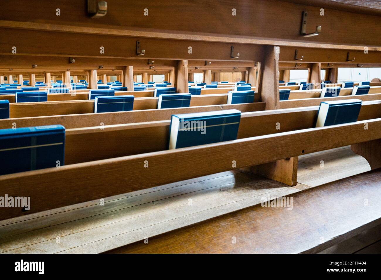 Selective focus view of many wooden church pews with blue bibles Stock ...