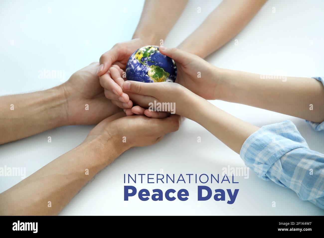 Hands of family with model of Earth on white background. International ...