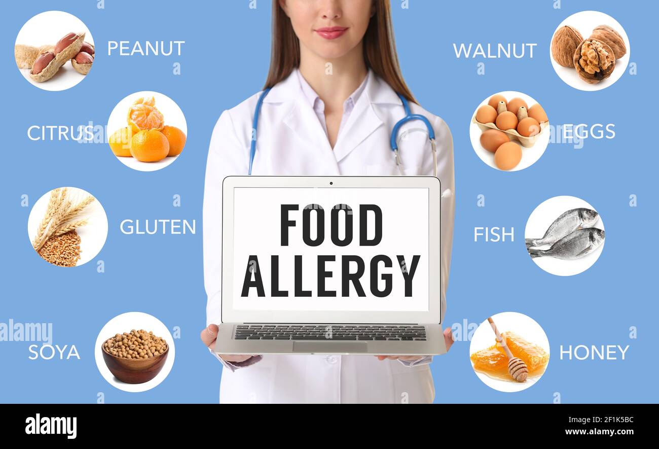 Young female doctor holding laptop with text "Food Allergy" on screen ...