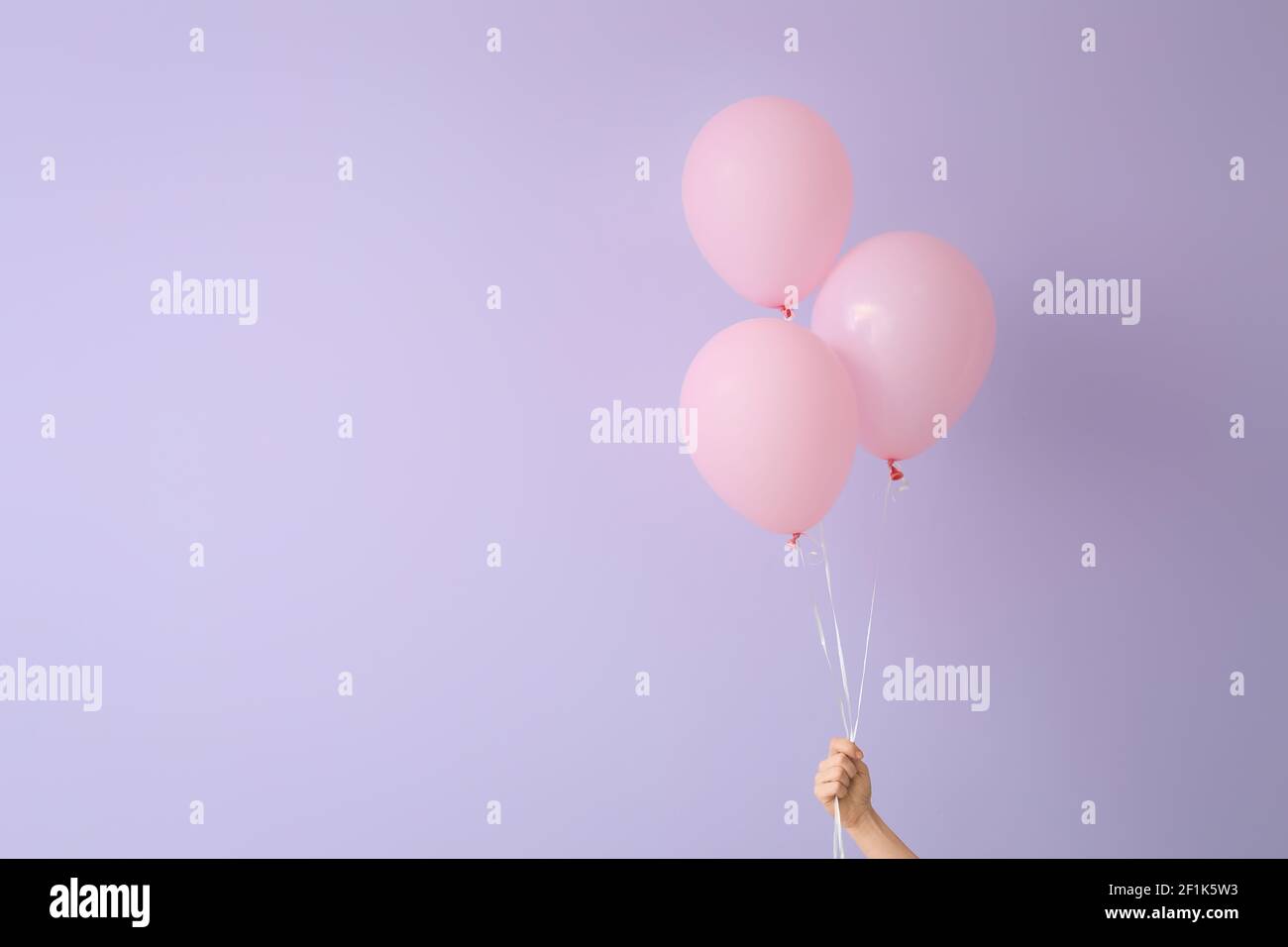 Human hand with air balloons on color background Stock Photo - Alamy