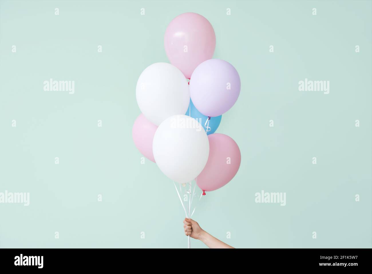 Human hand with air balloons on color background Stock Photo - Alamy