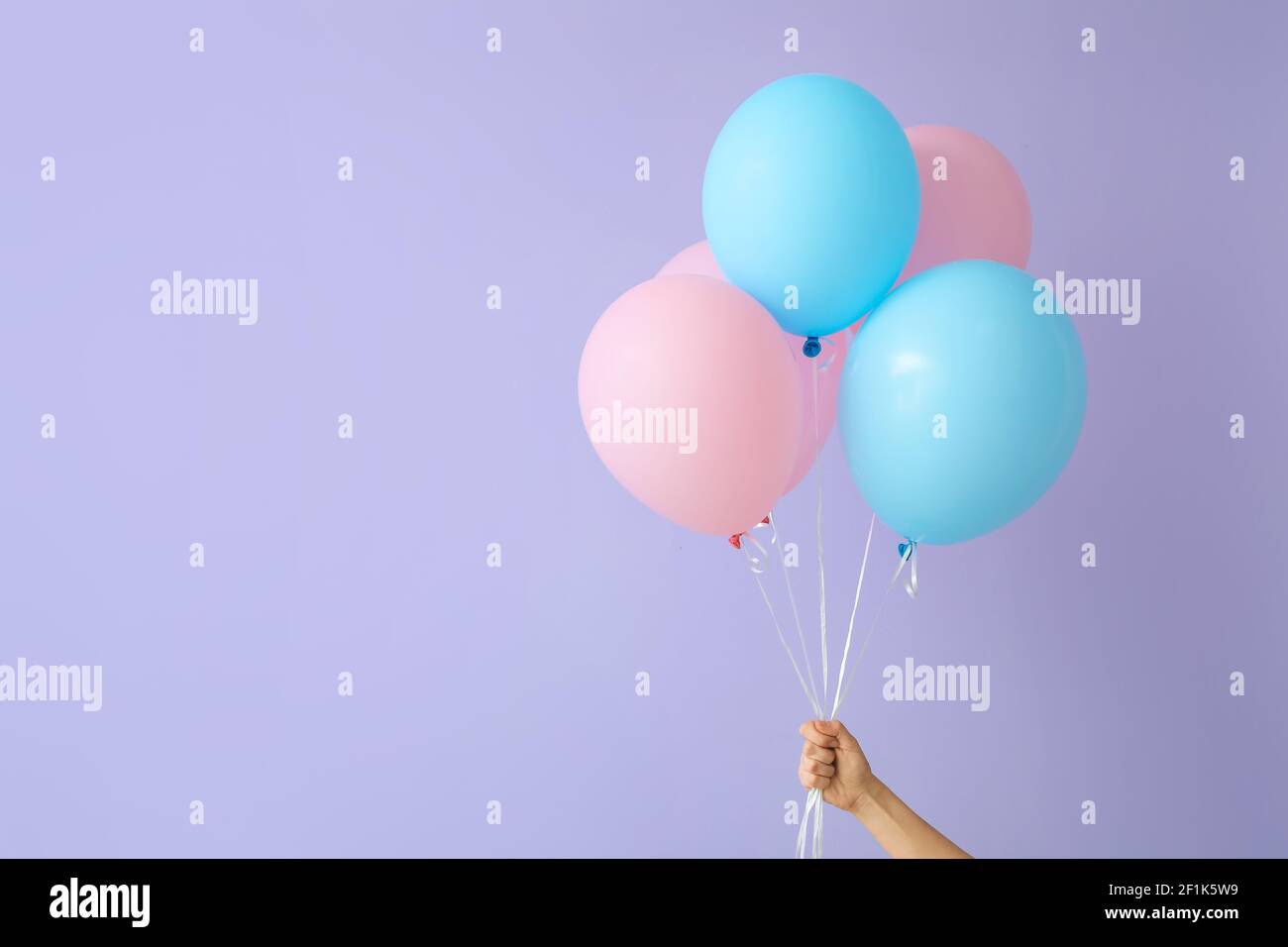 Human hand with air balloons on color background Stock Photo - Alamy