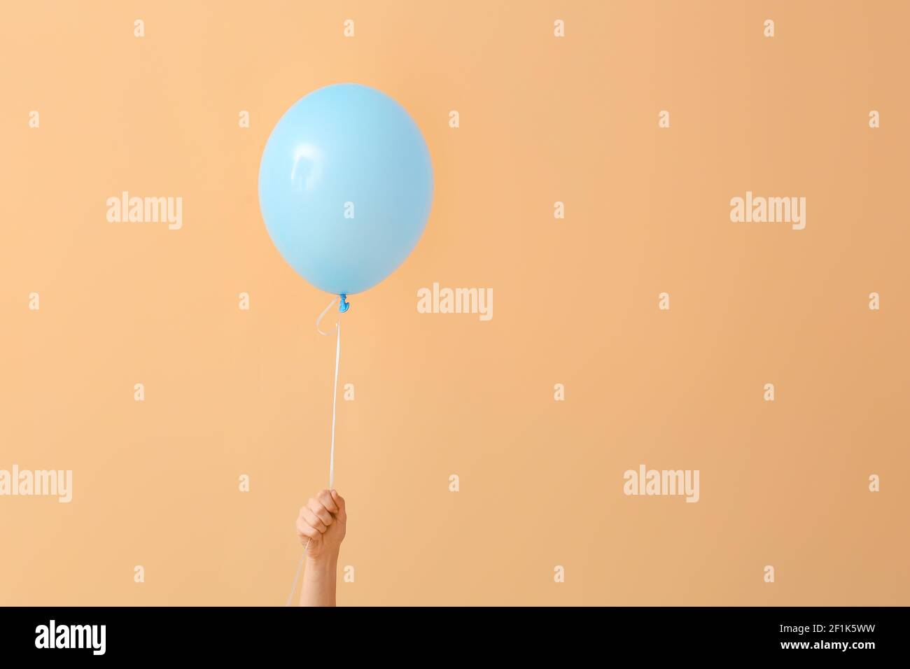 Human hand with air balloon on color background Stock Photo - Alamy