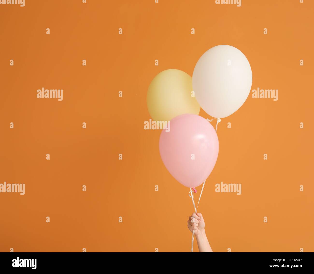 Human hand with air balloons on color background Stock Photo - Alamy