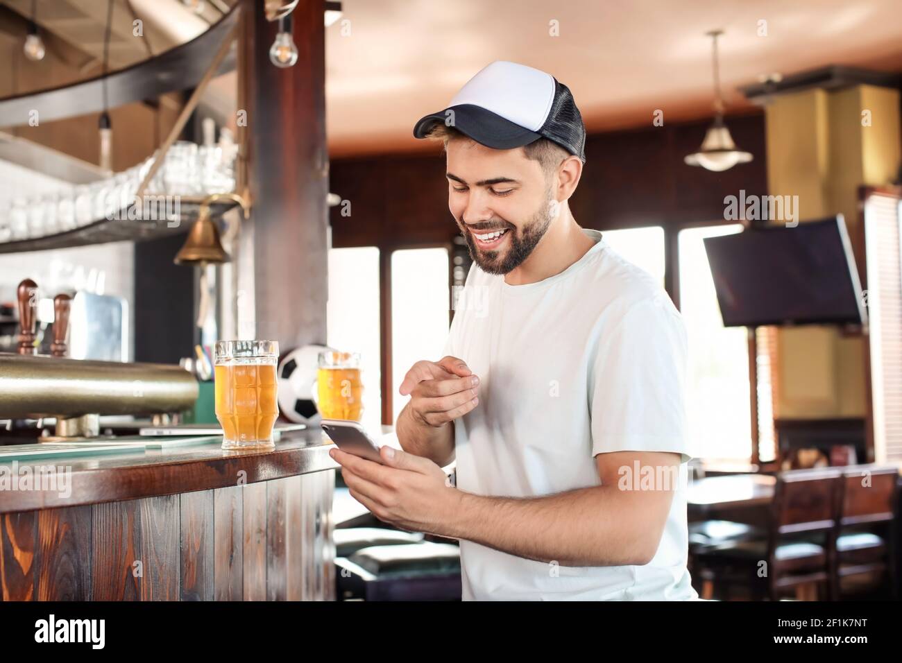 Happy young man after winning of his sports bet in pub Stock Photo - Alamy