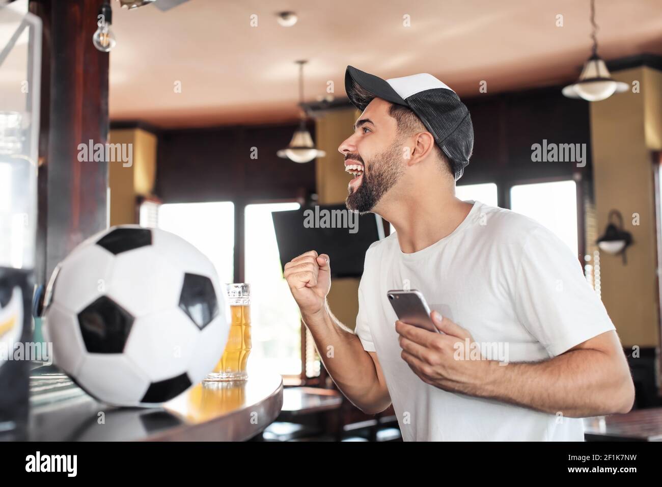 Happy young man after winning of his sports bet in pub Stock Photo - Alamy