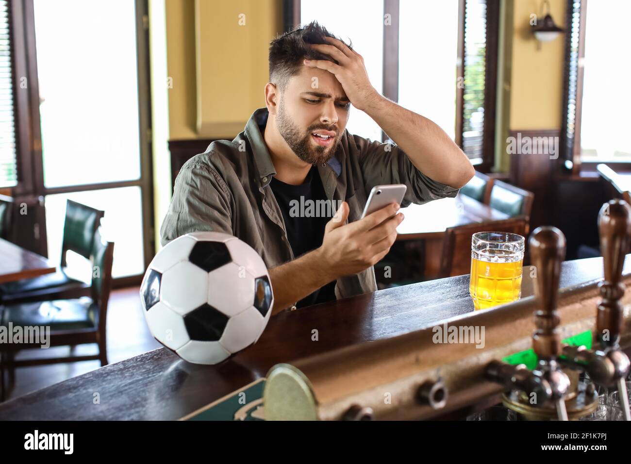 Sad young man after losing of his sports bet in pub Stock Photo - Alamy