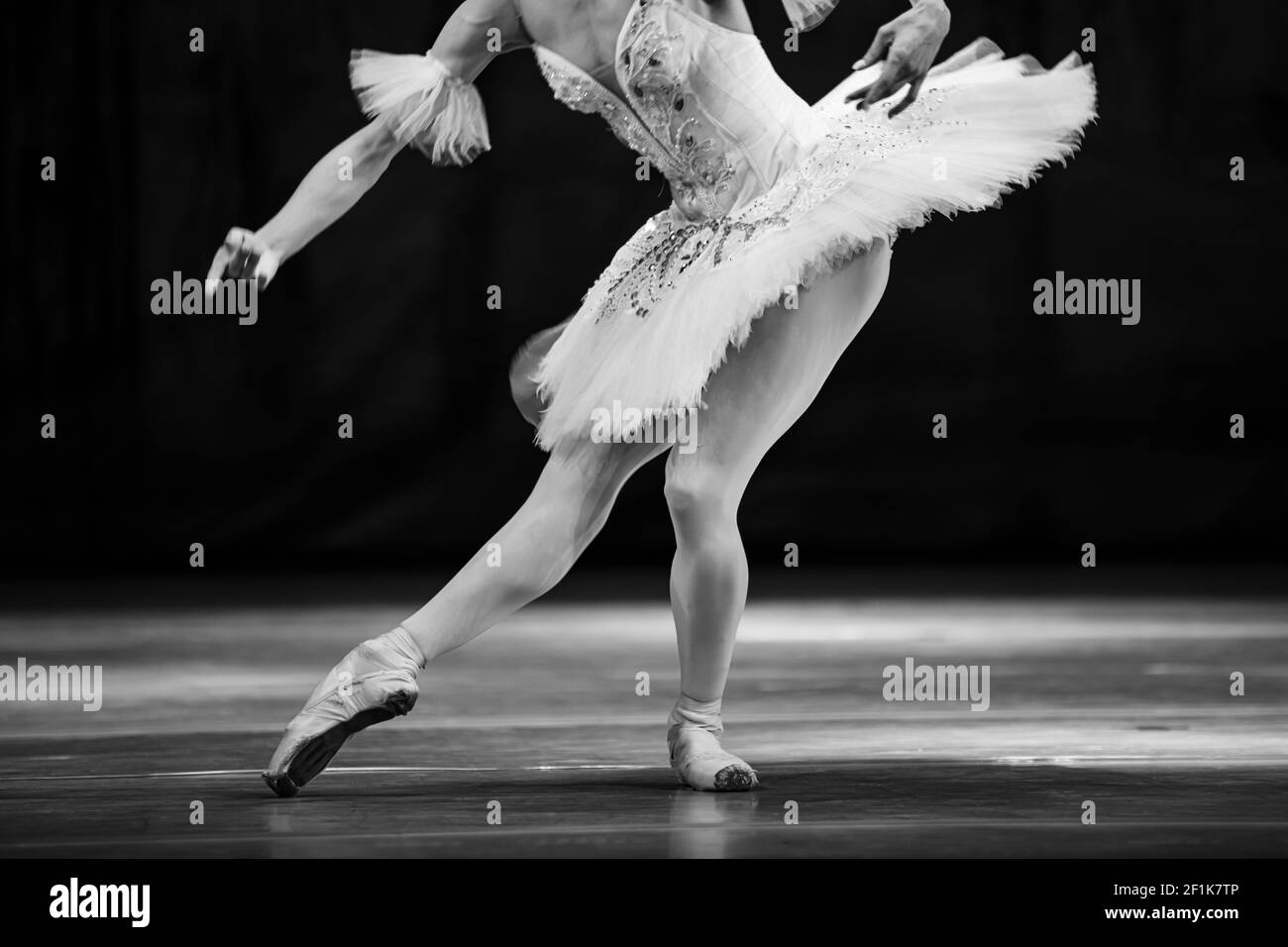 Closeup of ballerina dancing isolated on stage. Ballerina legs closeup ...