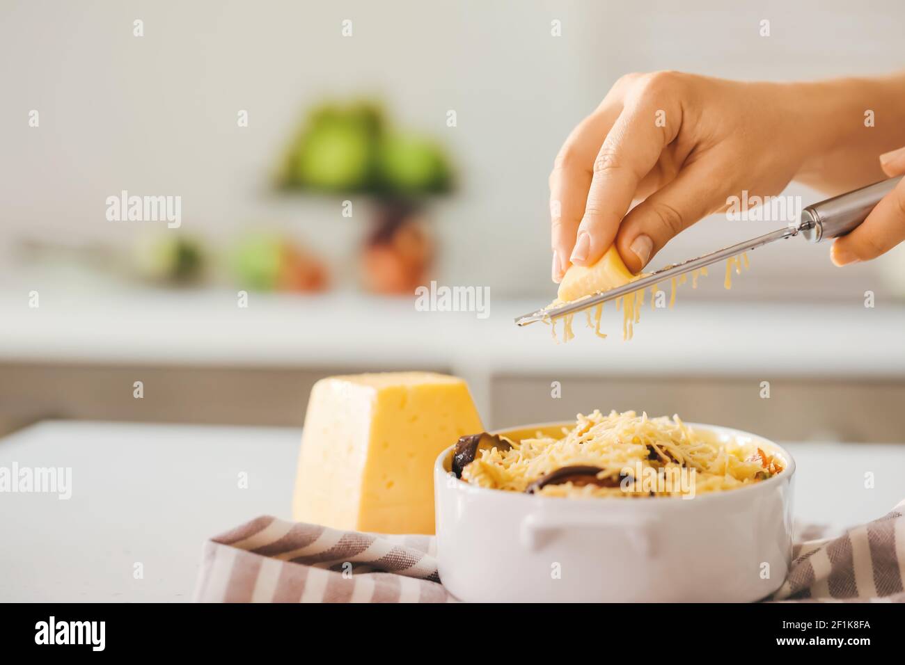 Woman grating cheese in kitchen, closeup Stock Photo - Alamy