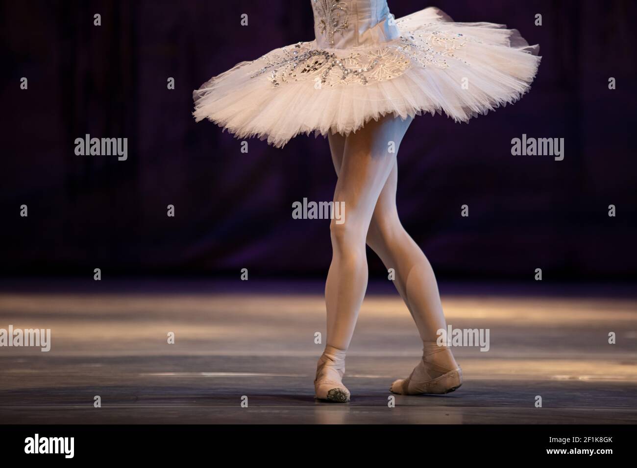 Closeup of ballerina dancing isolated on stage. Ballerina legs closeup ...