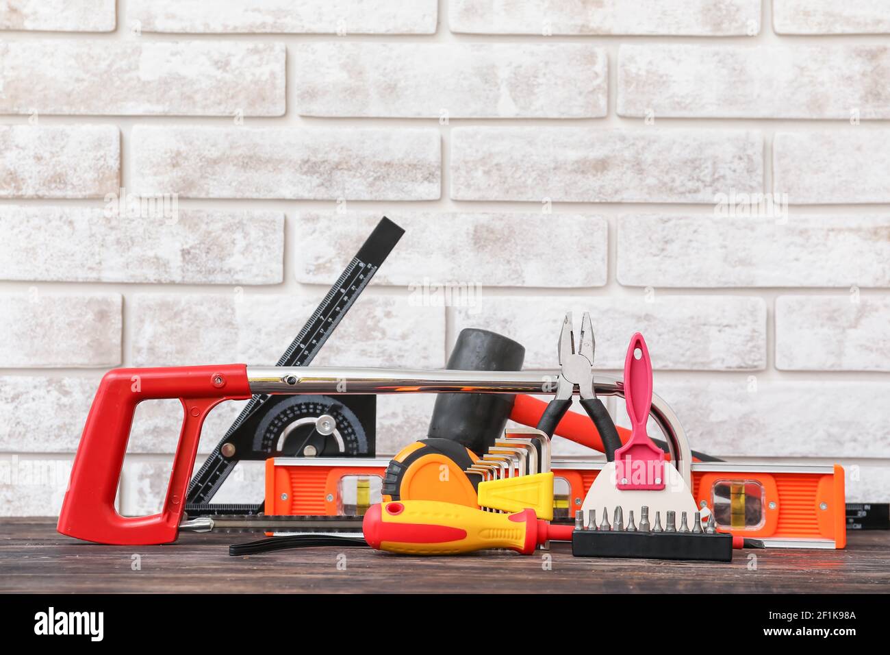 Set of construction tools on table against brick wall Stock Photo - Alamy