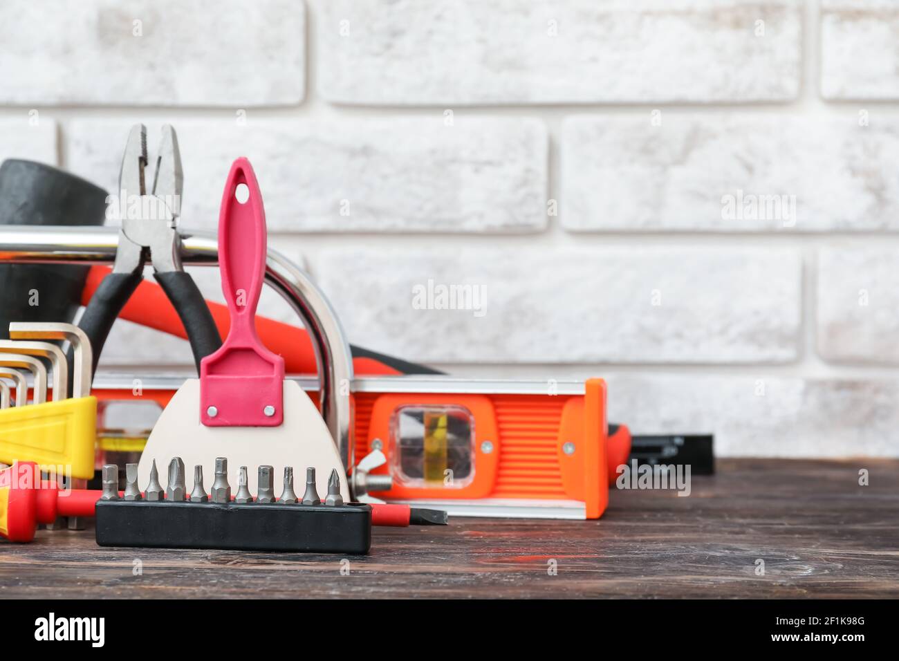 Set of construction tools on table against brick wall Stock Photo - Alamy