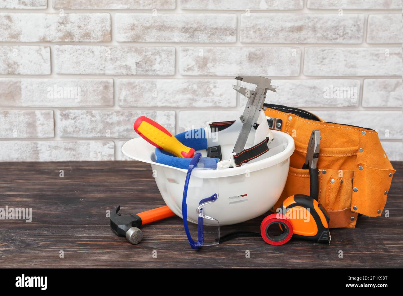Set of construction tools on table against brick wall Stock Photo - Alamy