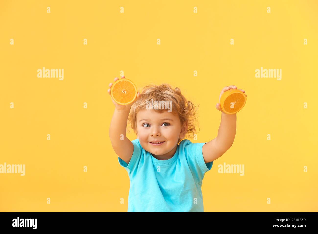 Funny little boy with orange on color background Stock Photo - Alamy