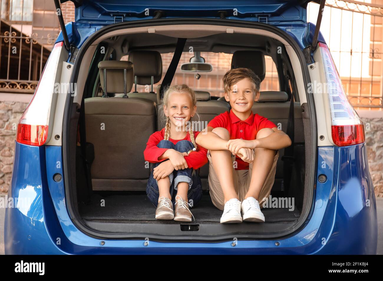 Happy kids sitting in car trunk outdoors Stock Photo - Alamy