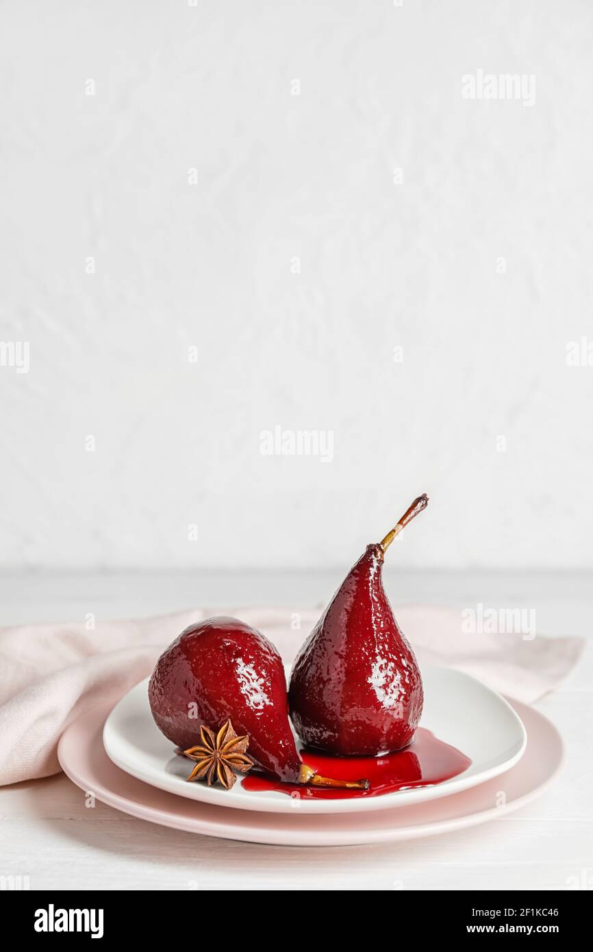 Plate with sweet poached pears in red wine on light background Stock ...