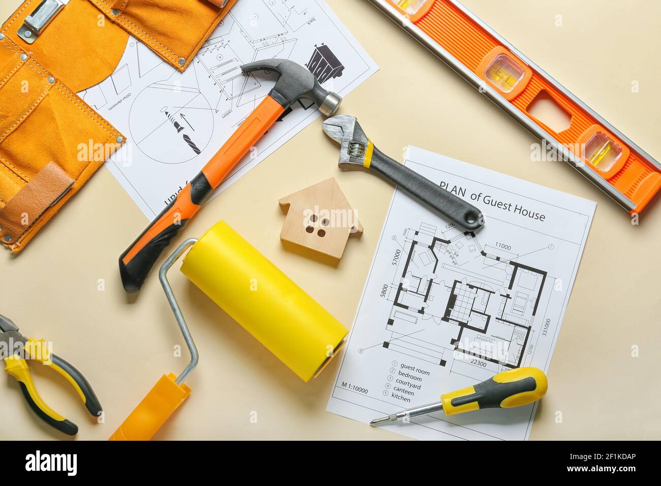 Composition with figure of house and construction tools on light ...