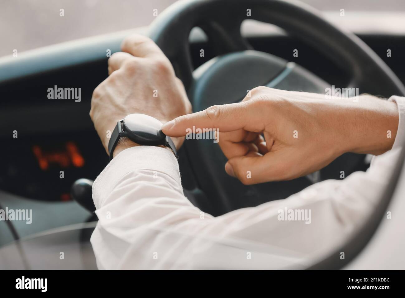 Young man with modern smart watch driving car Stock Photo - Alamy