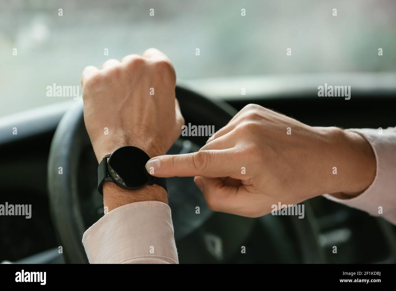 Young man with modern smart watch driving car Stock Photo - Alamy
