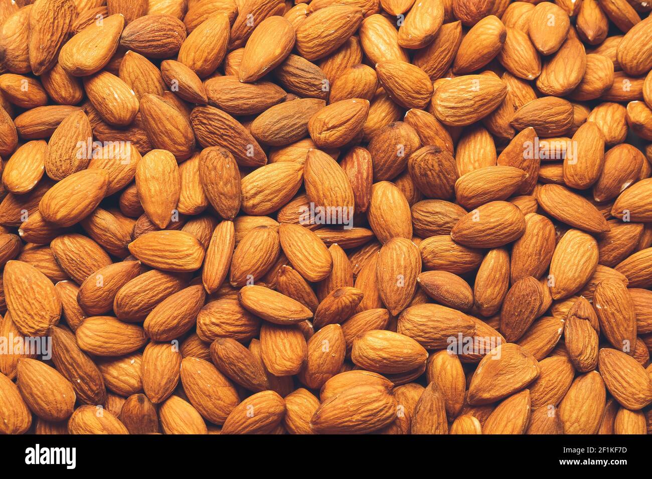 Many tasty almonds as background Stock Photo - Alamy