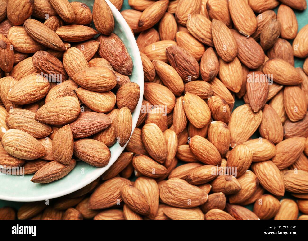 Plate with tasty almonds on table, closeup Stock Photo - Alamy