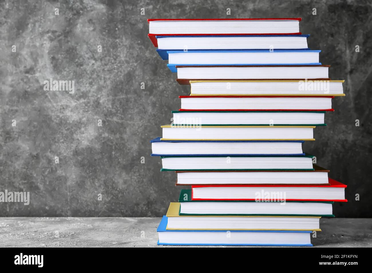 Stack of books on grey background Stock Photo - Alamy